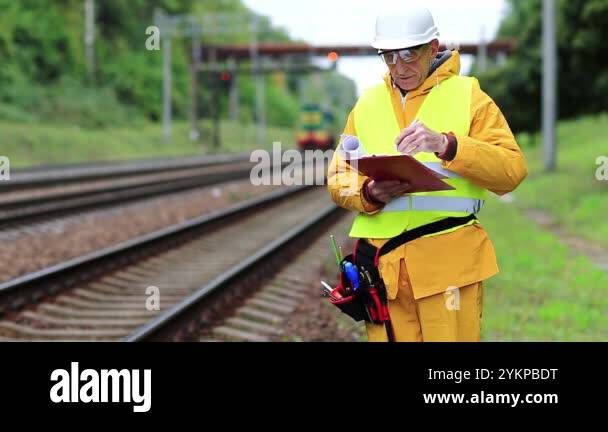 Inspector of railway traffic. Railway worker in yellow uniform with ...