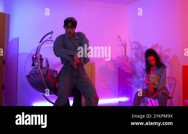 Skilled asian dancer moving to modern music while multicultural friend ...