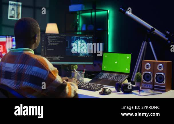 African american man using AI to develop a software system with chroma key on pc, cloud ...