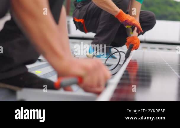 Installation, Connection and mounting of solar panels. Two workers fasten solar panels ...