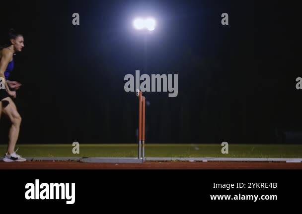 Female Athlete is Running Towards an Obstacle, Hurdling, Jumping Over ...