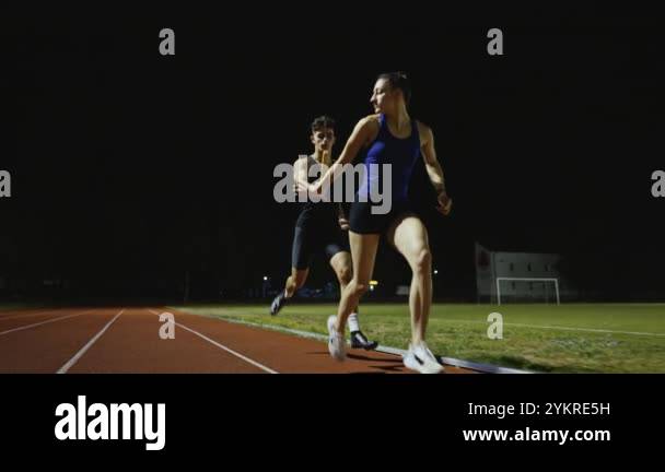 Athletes couple, male and female running a relay race and pass the ...