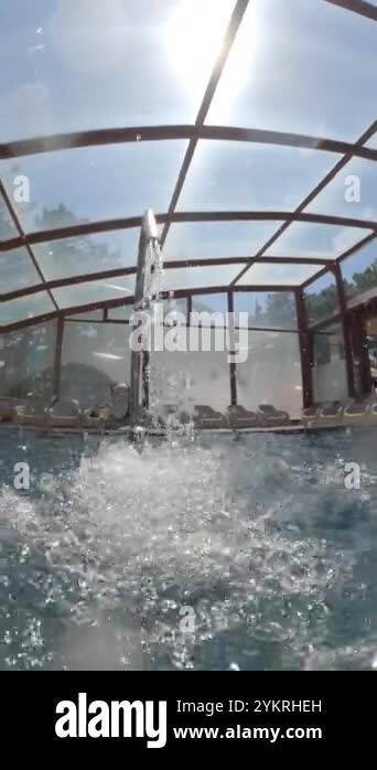 Close-up of a water fountain splashing in an indoor pool with a glass ...