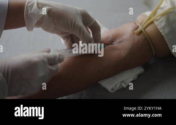 close up of doctor or nurse taking a blood sample from arm vein with a ...