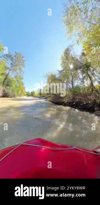 Vertical video. A side-angle view from inside a rafting boat as the ...