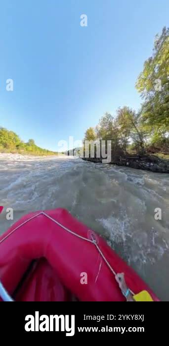 Vertical video. A front-facing view of a rafting boat approaching a ...