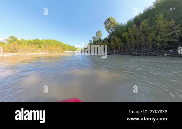 A wide view from the back of a rafting boat on a sunny day, with two ...
