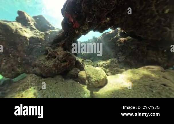 360 rotation. Low angle underwater view through a rock formation ...