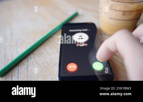 A hand reaching to decline an incoming scam call on a smartphone screen ...