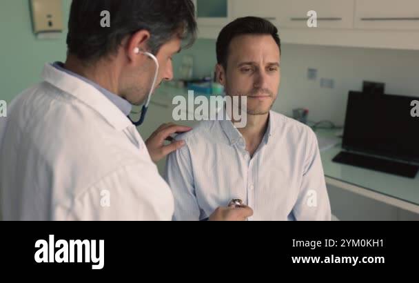 In medical examination room male cardiologist places stethoscope ...