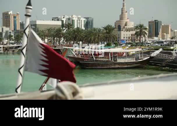 Flag of Qatar on the boat in harbour, islamic cultural center Fanar in ...