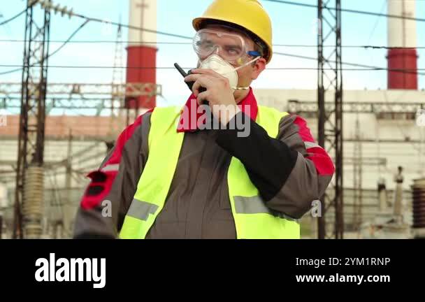 Workman in gas mask speaks via radio transmitter. Power engineering ...