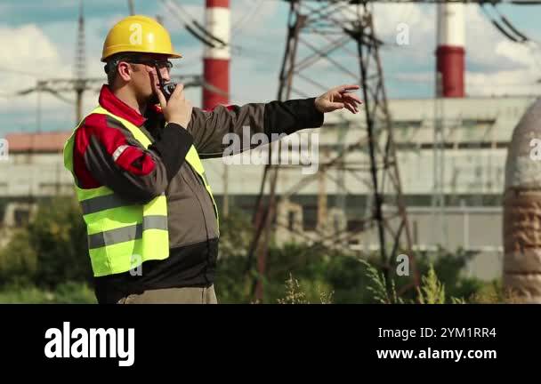 Factory worker with portable radio transmitter on electric power ...