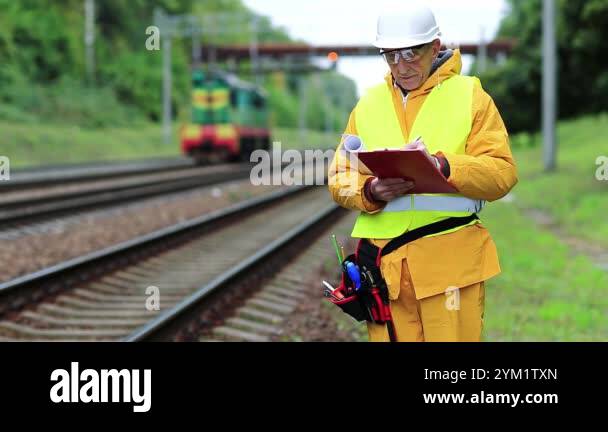 Inspector of railway traffic. Railway worker in yellow uniform with ...
