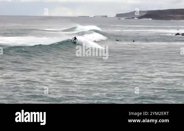 Surfers riding long waves at easter island showcase the thrill of ocean ...