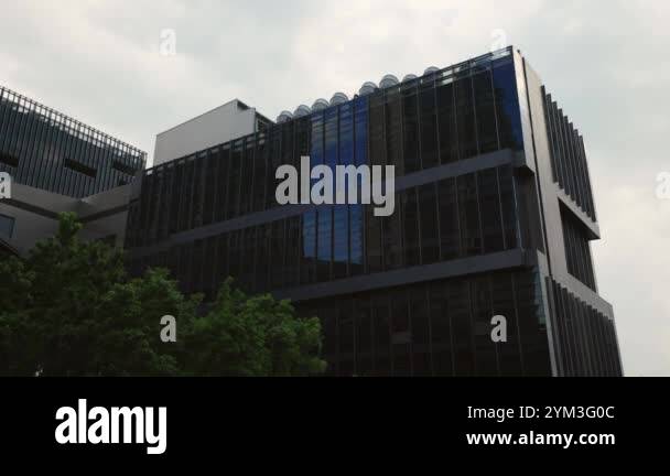A sleek office building features a reflective glass exterior and ...