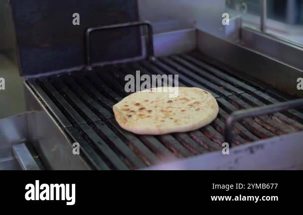A perfect flatbread is currently cooking on a commercial grill ...