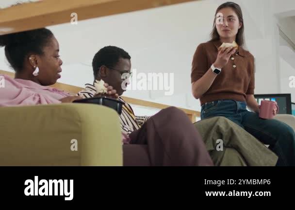 Three ethnically diverse coworkers taking break together in casual ...