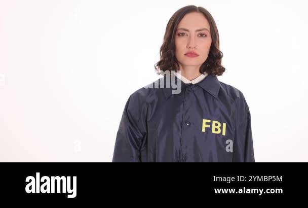 Female FBI agent raises up handcuffs on white background. Government ...