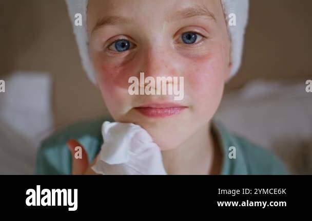 Beauty kid applying toner on skin closeup. Cute small girl in towel on ...