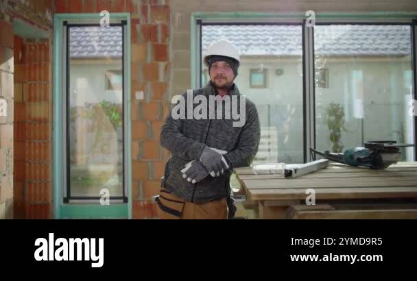Construction worker standing near workbench in building under ...