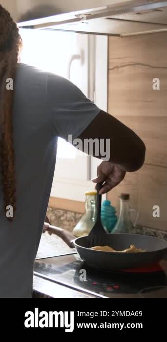 Chef flipping food in a pan with a spatula while cooking on a stovetop ...