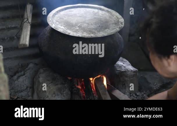 Traditional way of cooking food using firewood emitting smoke causing ...