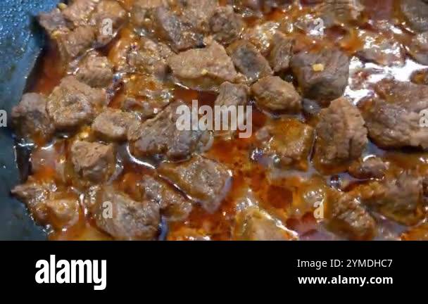 Tender chunks of beef simmer in a rich, tomato-based sauce, offering a ...