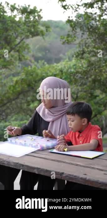 Indonesian mom in hijab and her son learn how to arrange letters in the ...