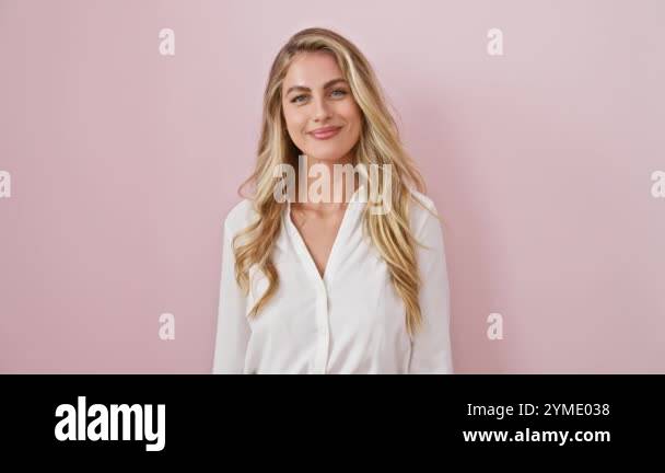 Cheerful blonde woman, standing in pink isolation, confidently showing ...