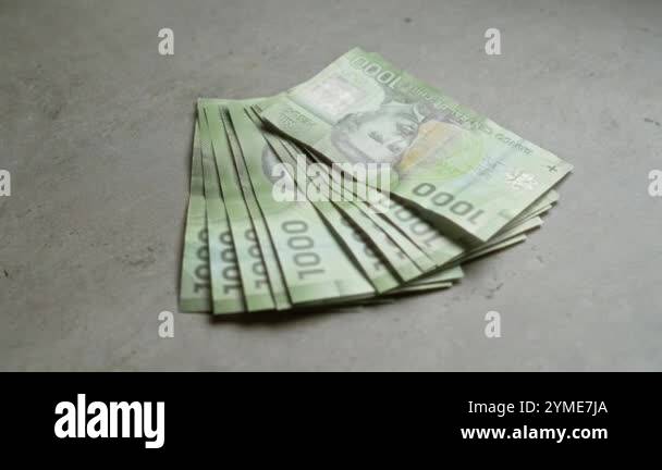 Stack of 1000 chilean pesos banknotes fanned out on a concrete surface ...