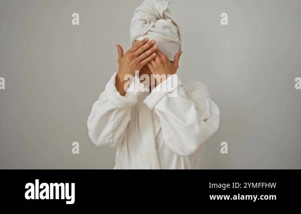 Middle age woman in towel and bathrobe, peeking through fingers with ...