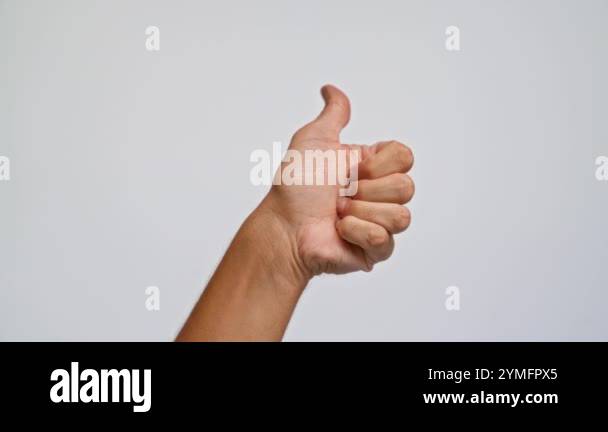 Man giving a thumbs up gesture with his hand against a plain white ...