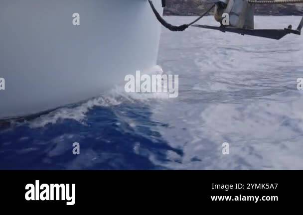 A close-up view of a boat sailing through the ocean focuses on the ...