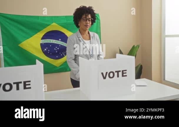 A beautiful african american woman voting indoors with a brazilian flag ...