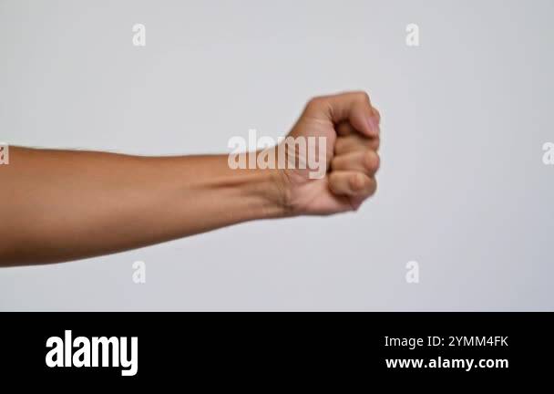 Man making a closed fist against a plain white background, displaying ...