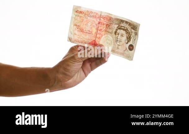 Hand holding fifty british pounds banknote on isolated white background ...