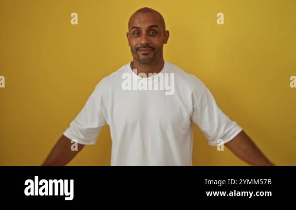 Strong handsome young man posing confidently over an isolated yellow ...