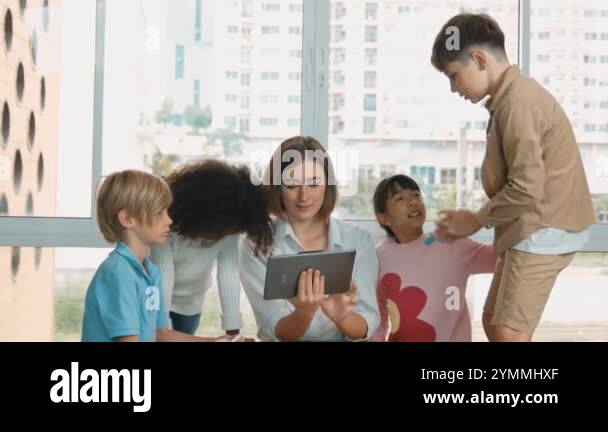 Smart teacher holding tablet while open online lesson to group of ...