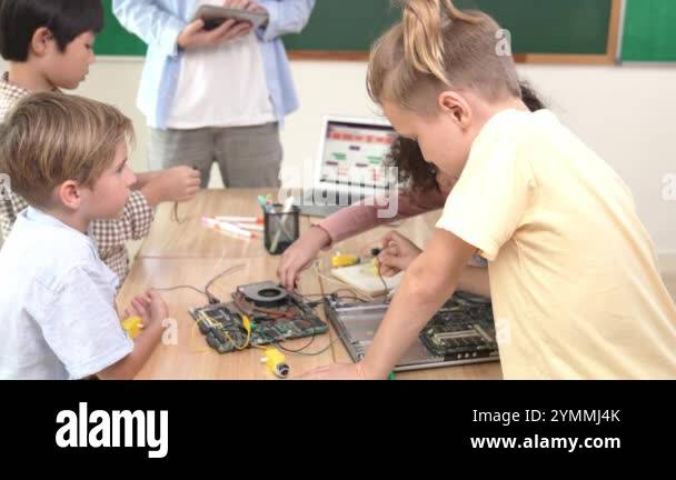 Cute energetic children working on electronic board while teacher using ...