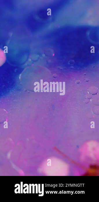 Vertical video. Bubble glitter paint. Floating flowers. Defocused pink ...