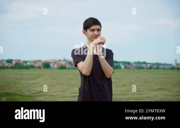 Teenage boy warming up wrists before outdoor fitness training. Young ...
