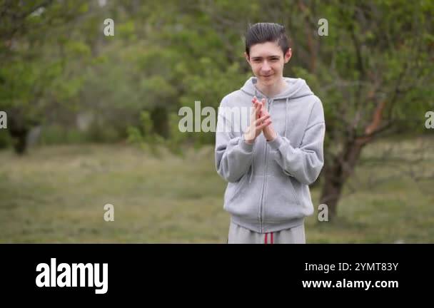 Happy teenage boy clapping hands outdoors, celebrating success. Joyful ...