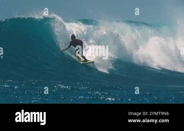 Surfer gets barrelled and falls. Male surfer confidently surfs the wave ...