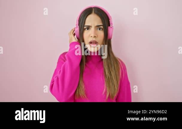 Beautiful young latin woman, skeptically listening to music over ...