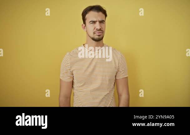 Irate young hispanic guy in striped tee unloads rage, yelling madly ...