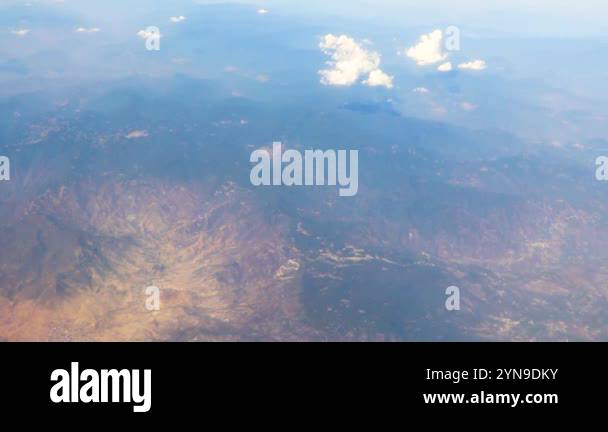 Flying in an airplane over Mexico clouds sky volcanoes mountains and ...