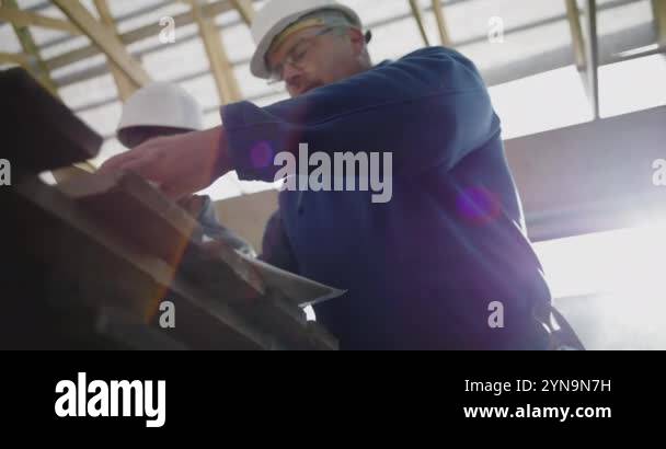 Construction supervisor gesturing and pointing while reviewing building ...