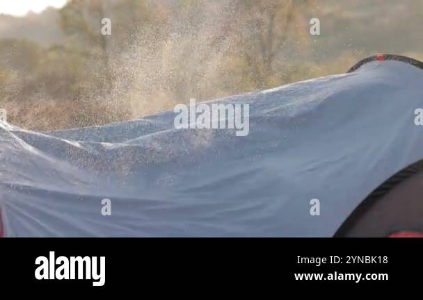 Removing water droplets from night condensation from a tent. Shaking ...