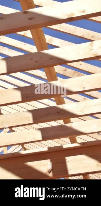 Wooden beams supporting an open roof structure integrated into large frame for construction ...
